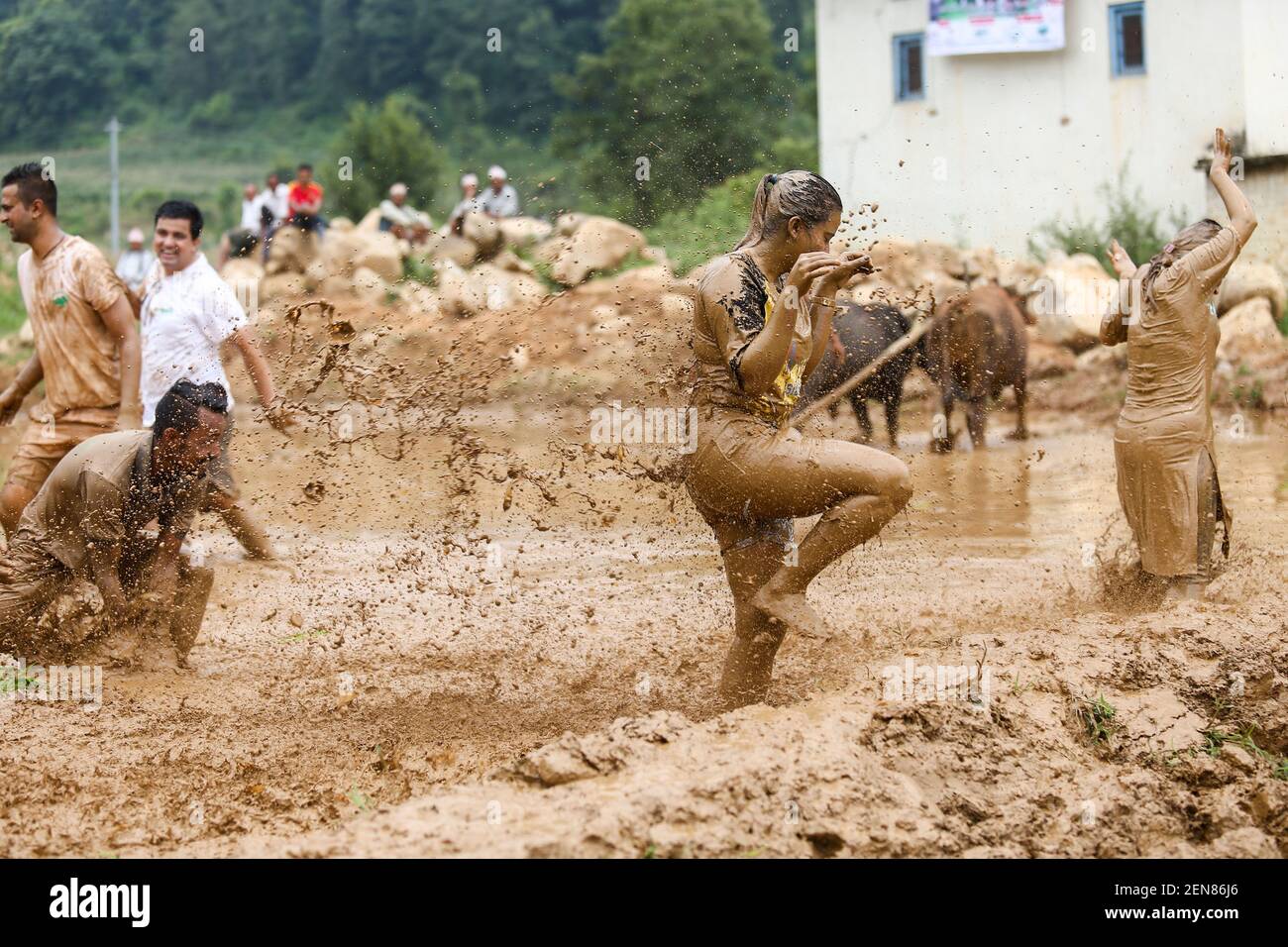 People are seen playing in the mud water as they plant rice crops in a ...