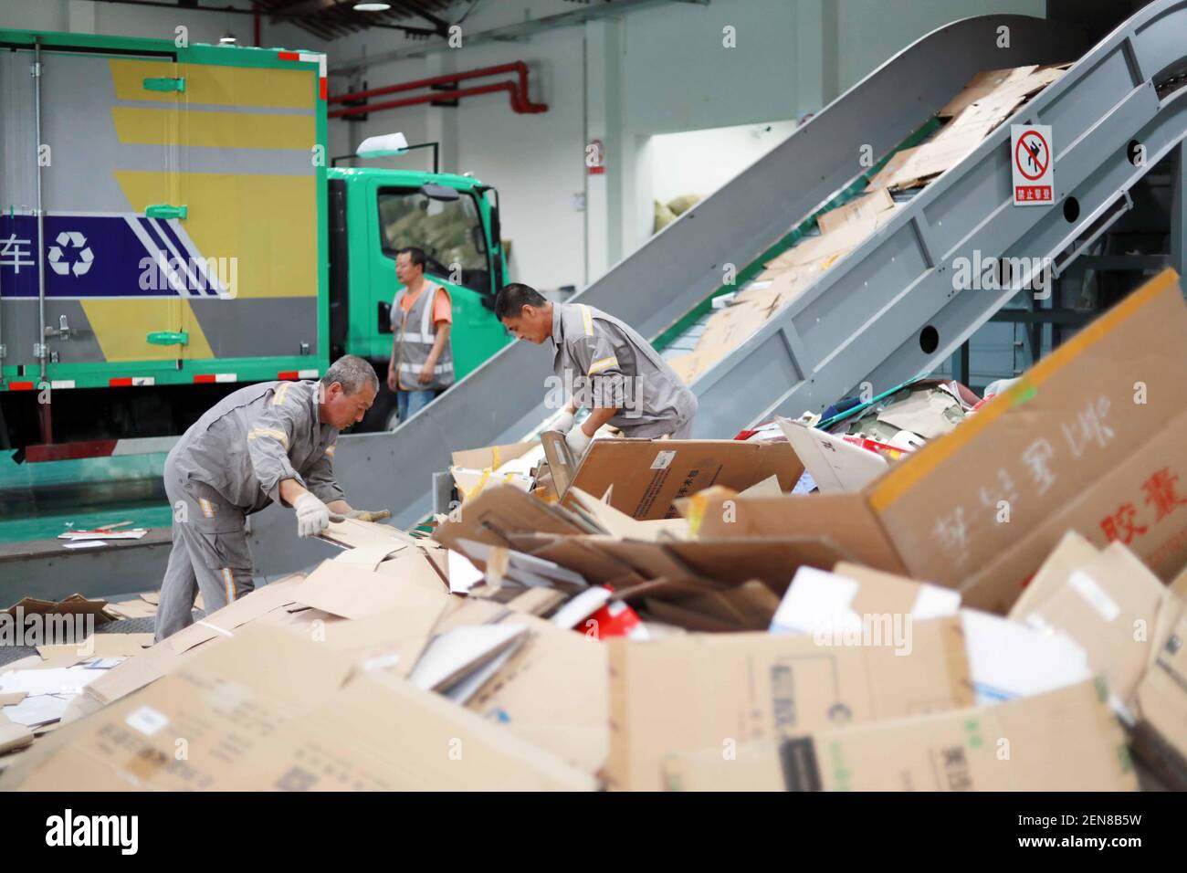 A Chinese worker sorts out recycling waste at a distribution center of ...