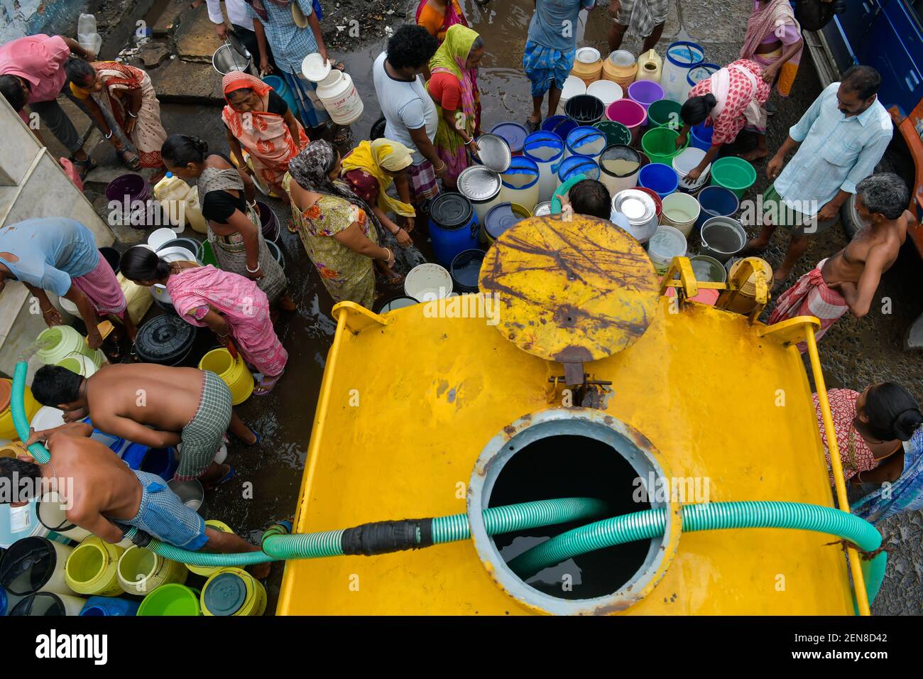Local residents fill their containers with drinking water from a ...