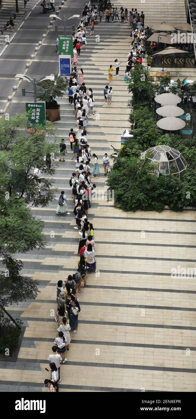 Chinese fans wait in a long queue in front of a milk tea store operated ...