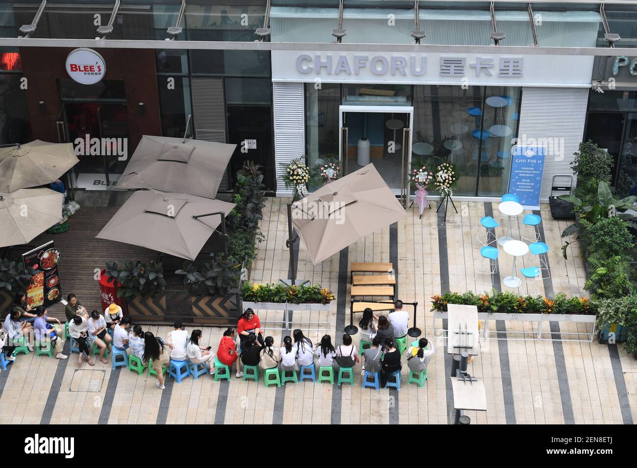 Chinese fans wait in a long queue in front of a milk tea store operated ...