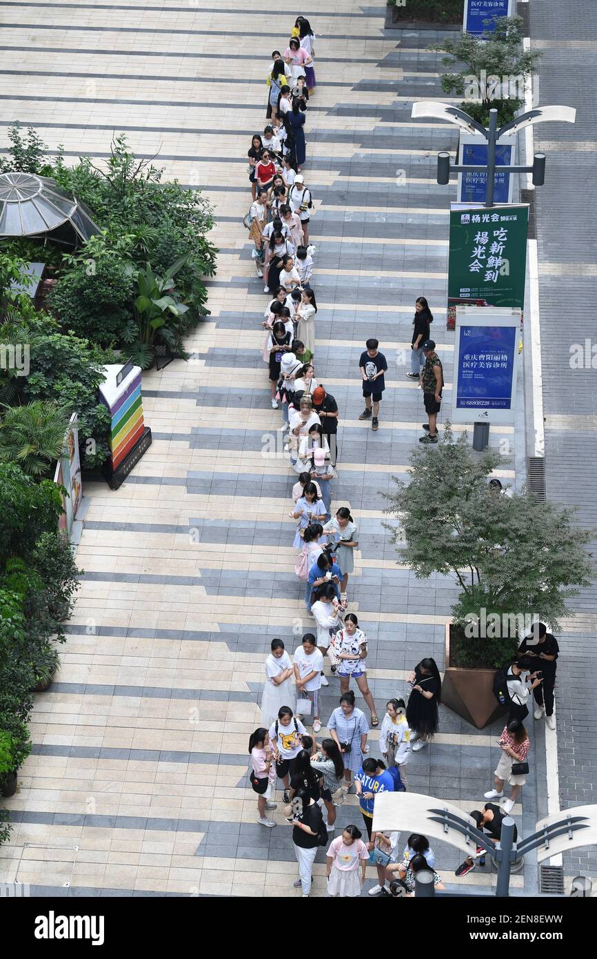 Chinese fans wait in a long queue in front of a milk tea store operated ...