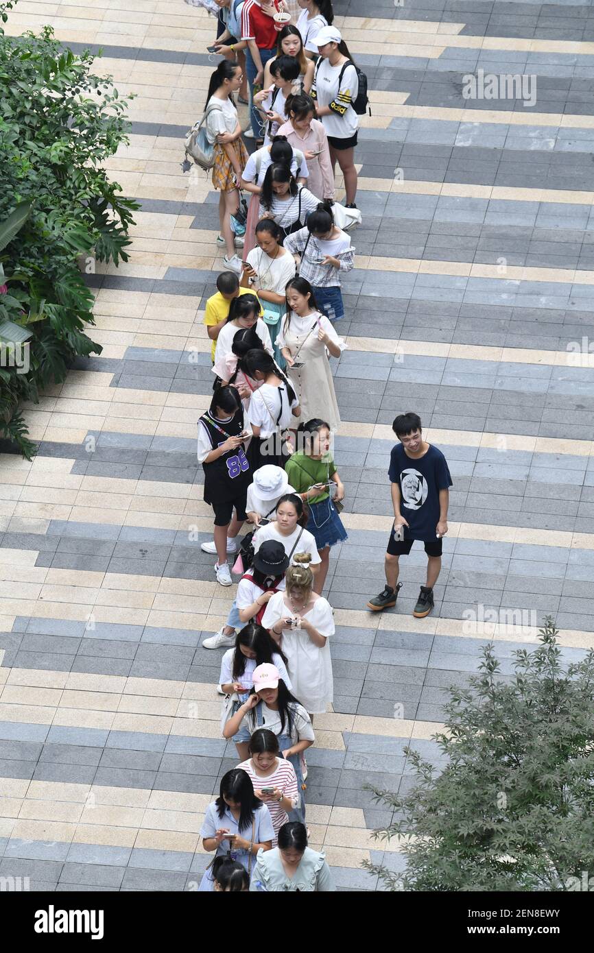 Chinese fans wait in a long queue in front of a milk tea store operated ...