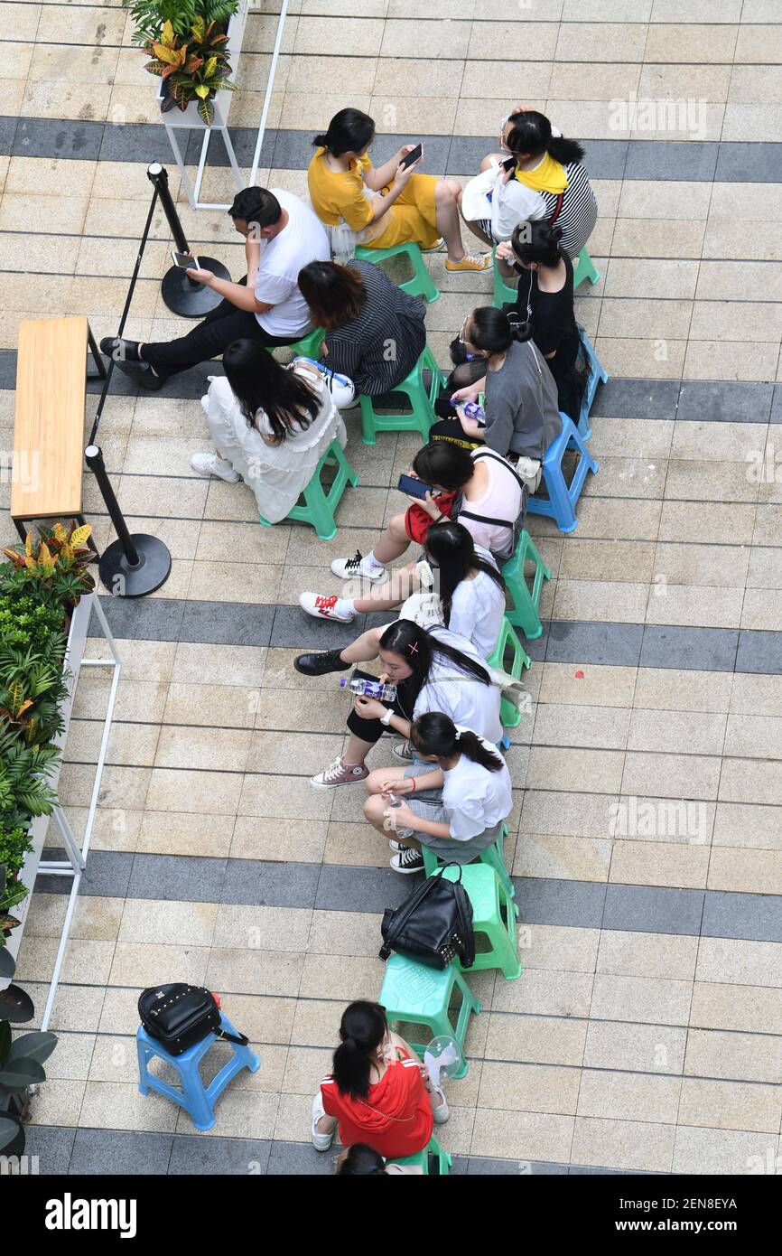 Chinese fans wait in a long queue in front of a milk tea store operated ...