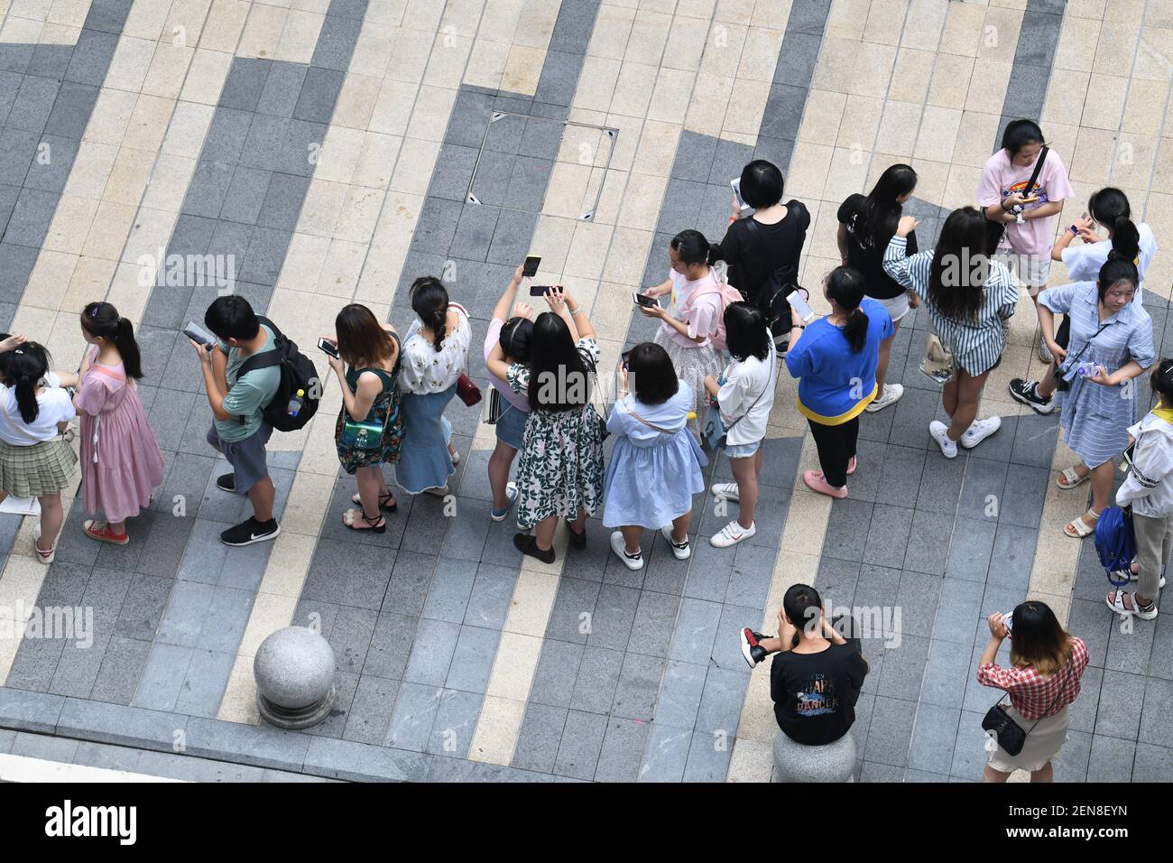 Chinese fans wait in a long queue in front of a milk tea store operated ...