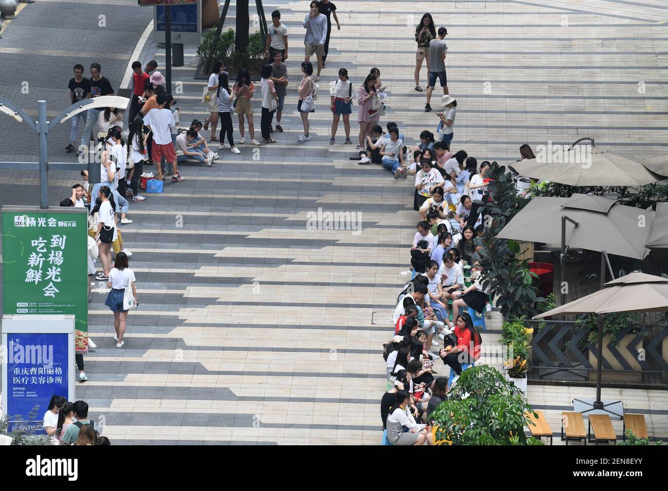 Chinese fans wait in a long queue in front of a milk tea store operated ...