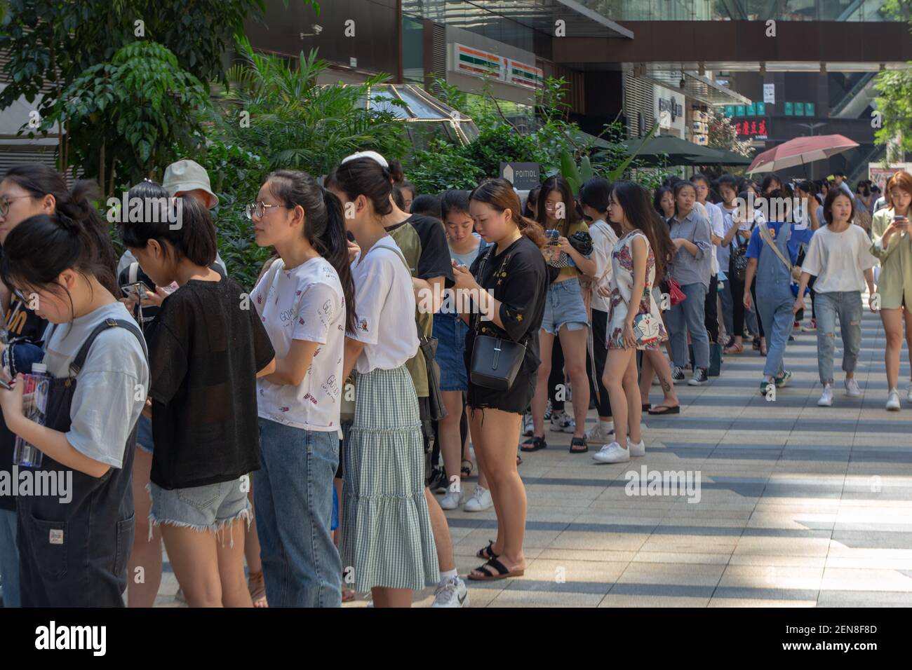 Chinese fans wait in a long queue in front of a milk tea store operated ...