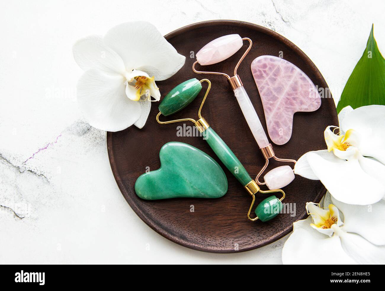 Jade face rollers for beauty facial massage therapy. Flat lay on white ...