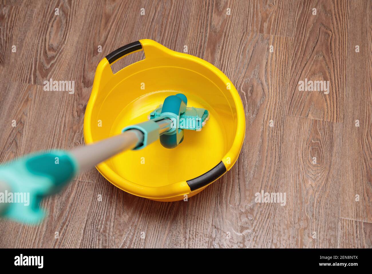 Blue mop with yellow basin for cleaning floors. Cleaning a floor from a ...