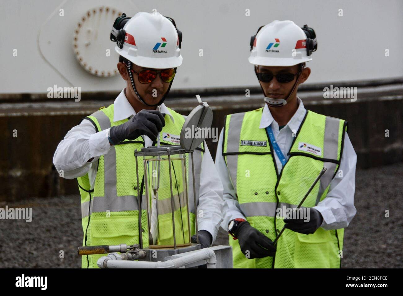 Indonesian workers PT. Pertamina checks aircraft fuel before it is ...