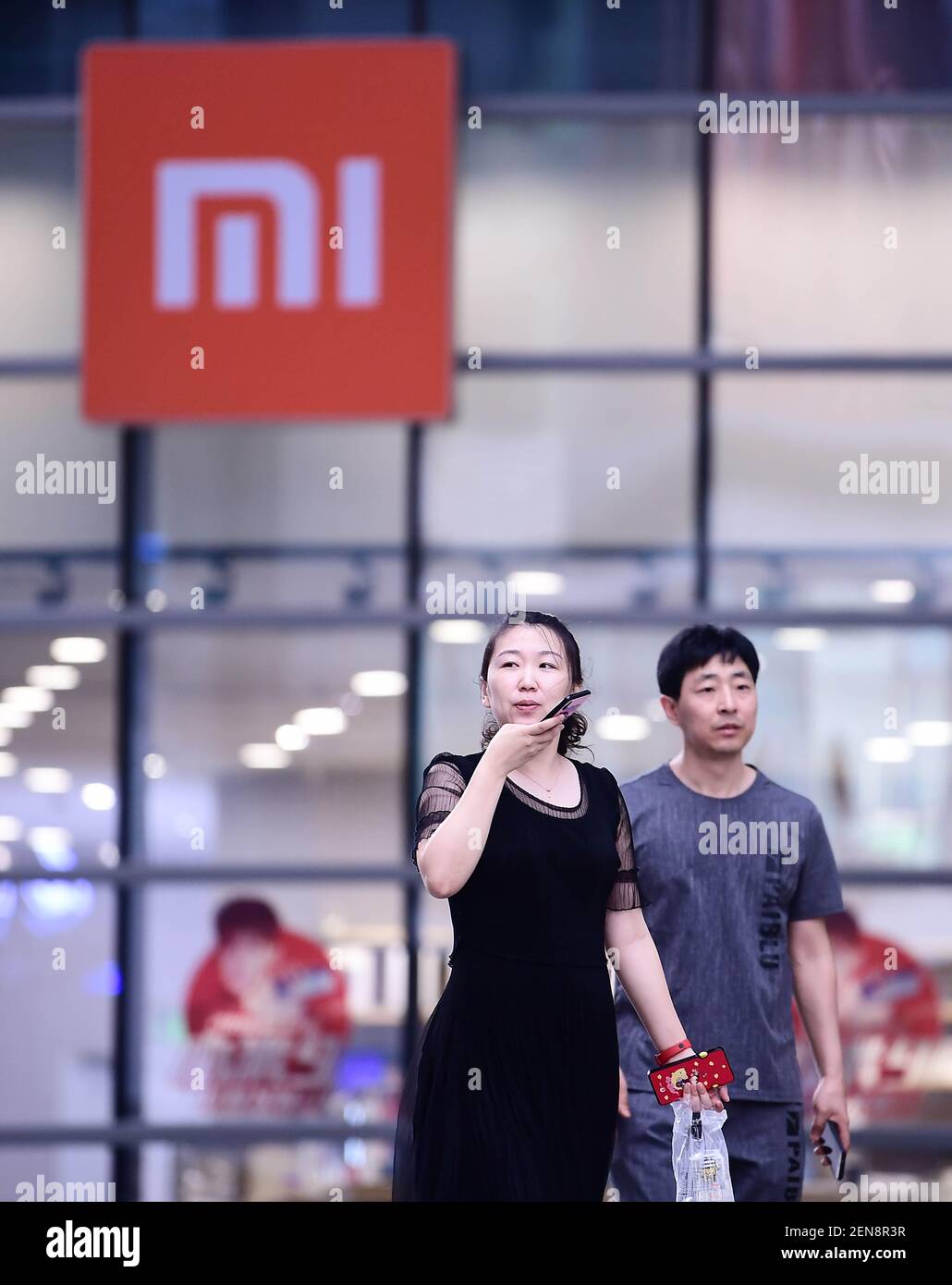 Pedestrians walk past a store of China's tech giant Xiaomi in Shenyang ...