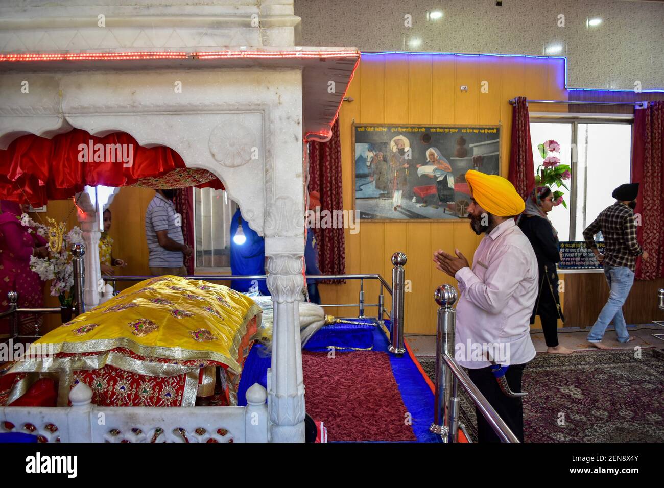 A devotee prays at a Sikh temple during a birth anniversary of the ...