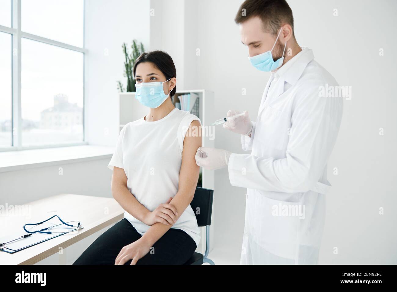 doctor and patient wearing medical masks covid-19 injection vaccination ...