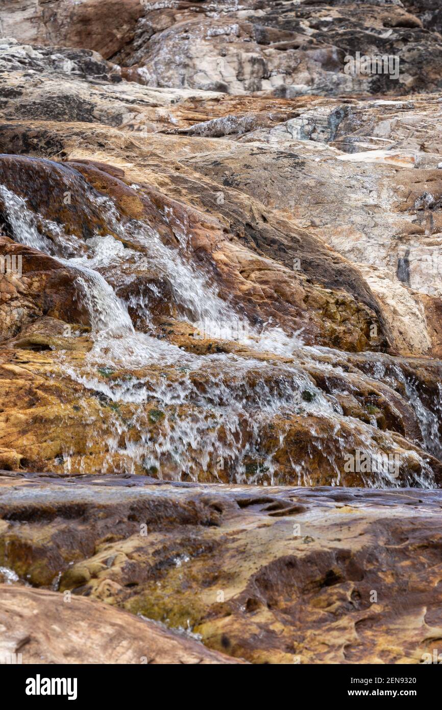 Water flowing down a small waterfall in an almost dried out river ...