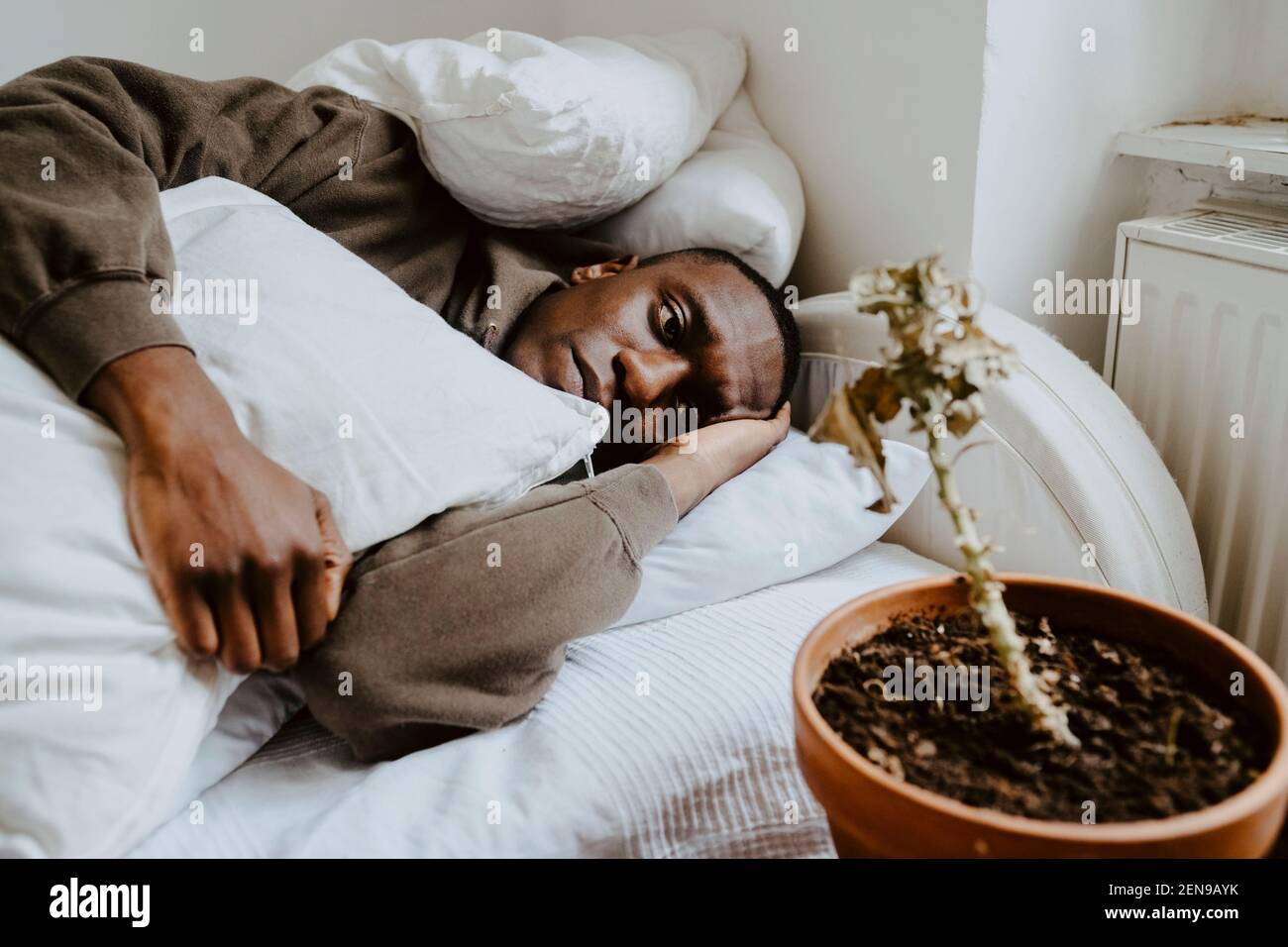 Exhausted young man resting on bed at home Stock Photo - Alamy