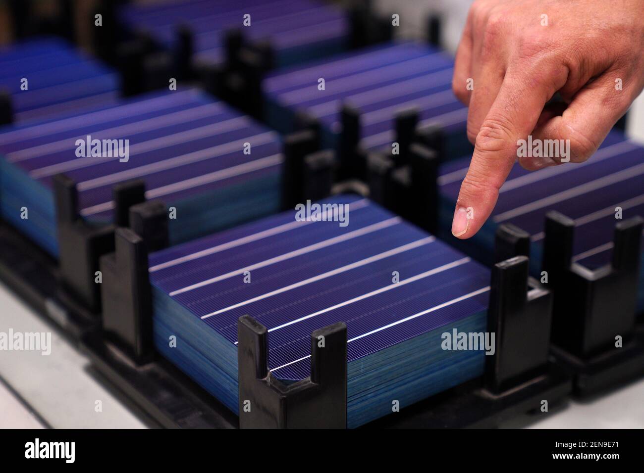 Martin Pochtaruk points out a stack of the individual solar cells that ...