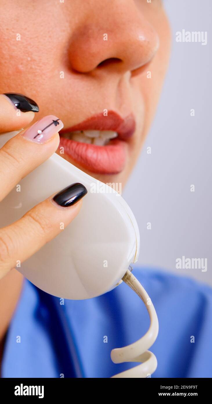 Close up of medical receptionist answering phone calls from patient in ...