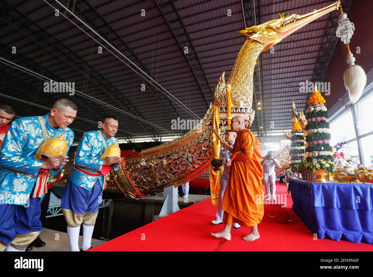 A Buddhist monk throw holy water on Thai oarsmen during a worship ...