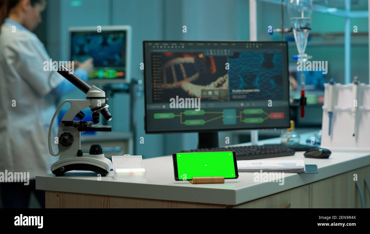 Scientist standing at monitor in background analysing virus evolution ...