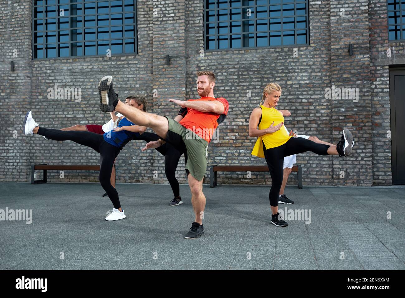 Martial art fitness coach teaching his students frontal leg kicks, leg ...