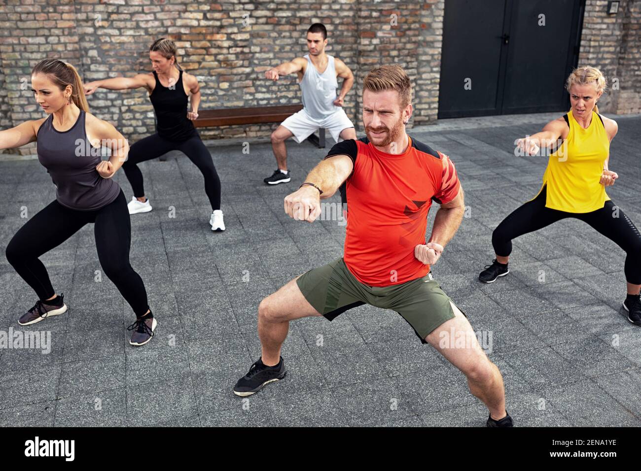 Martial artists dressed in fitness clothes practicing on the street ...