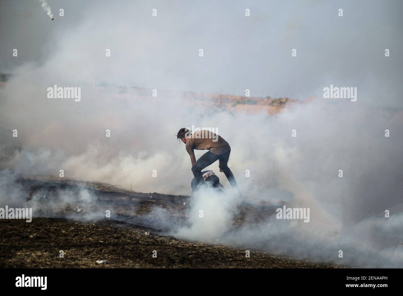 Palestinian demonstrators flee from the tear gas smoke during Clashes ...