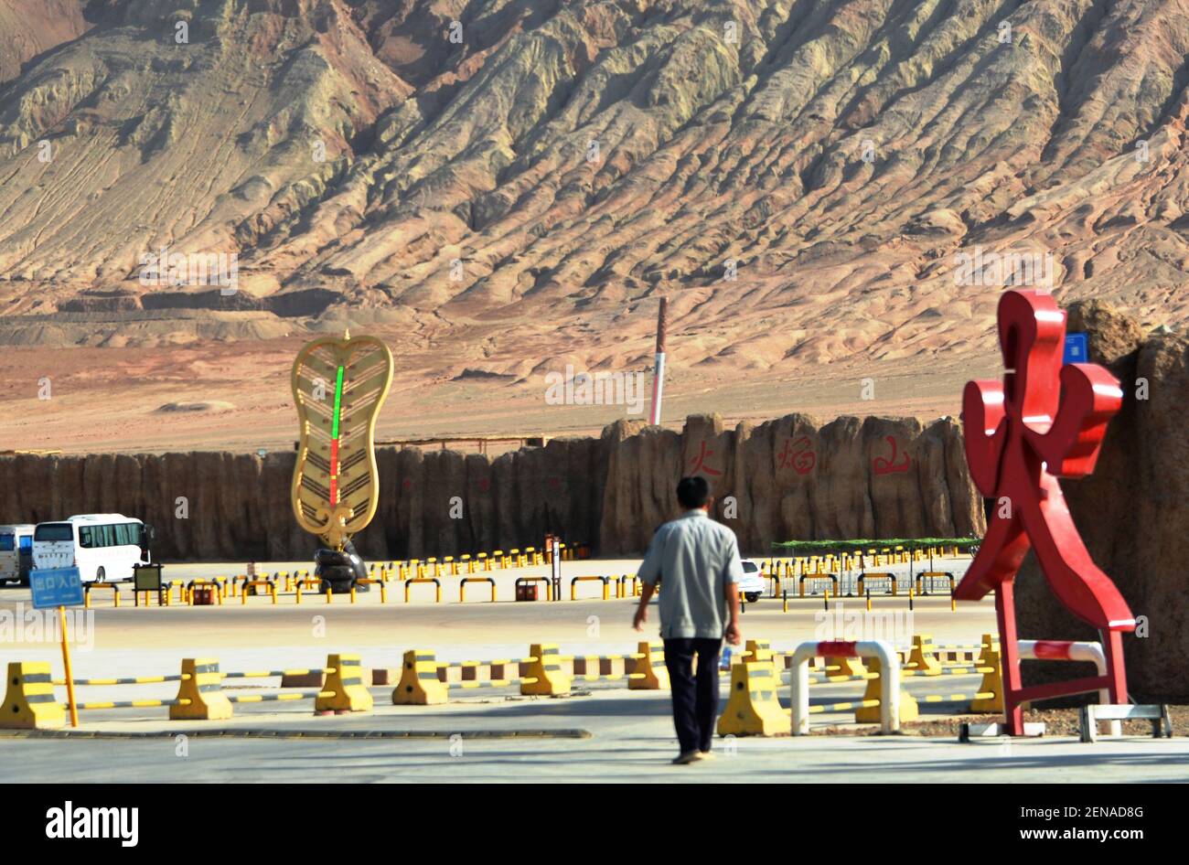 Tourists pose for photos with the landmark sculpture at the foot of the ...