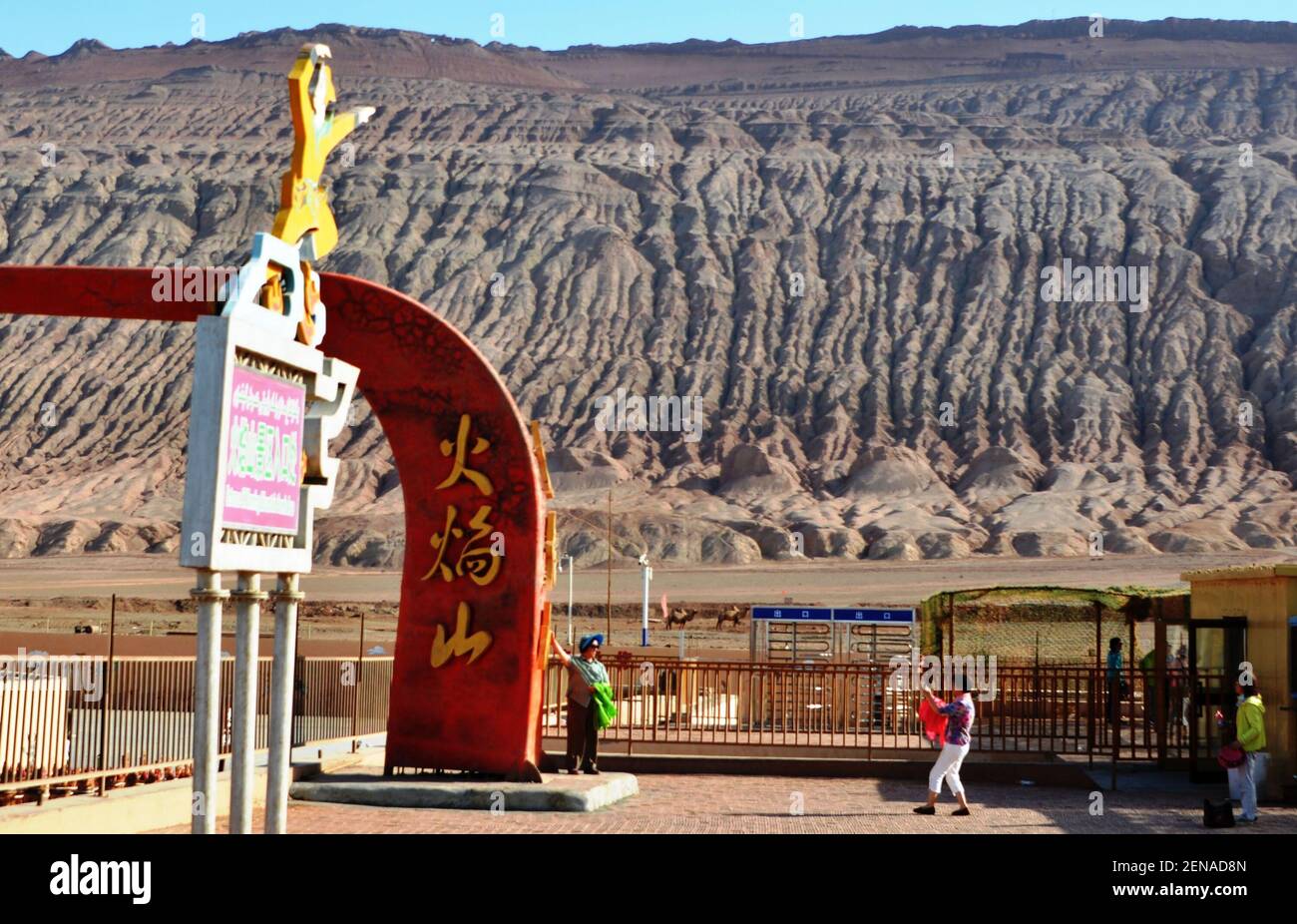 Tourists pose for photos with the landmark sculpture at the foot of the ...