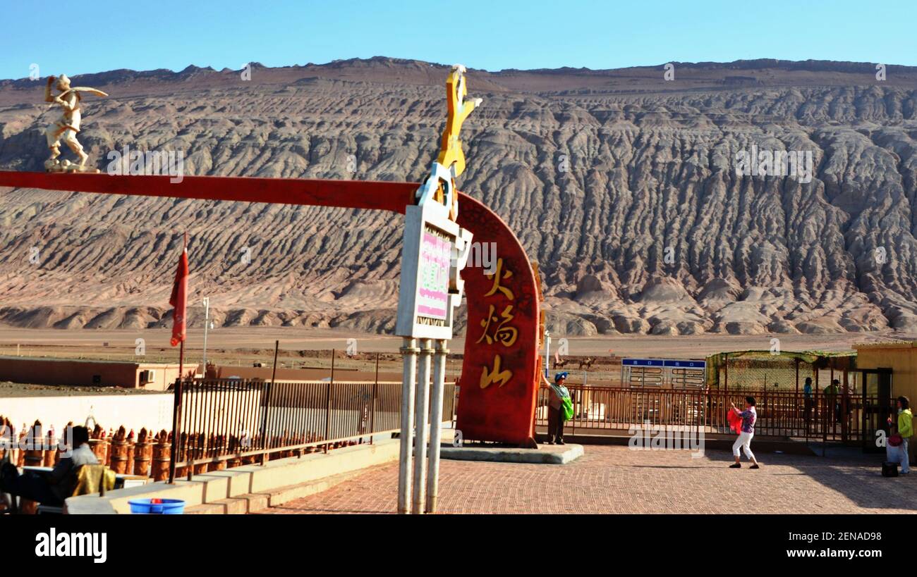 Tourists pose for photos with the landmark sculpture at the foot of the ...