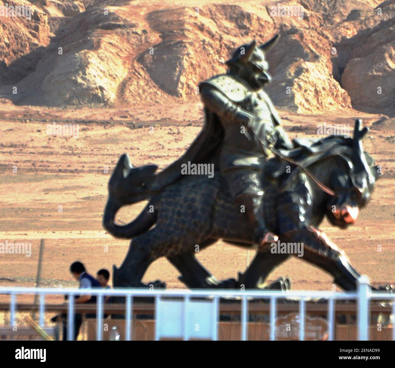 Tourists pose for photos with the landmark sculpture at the foot of the ...