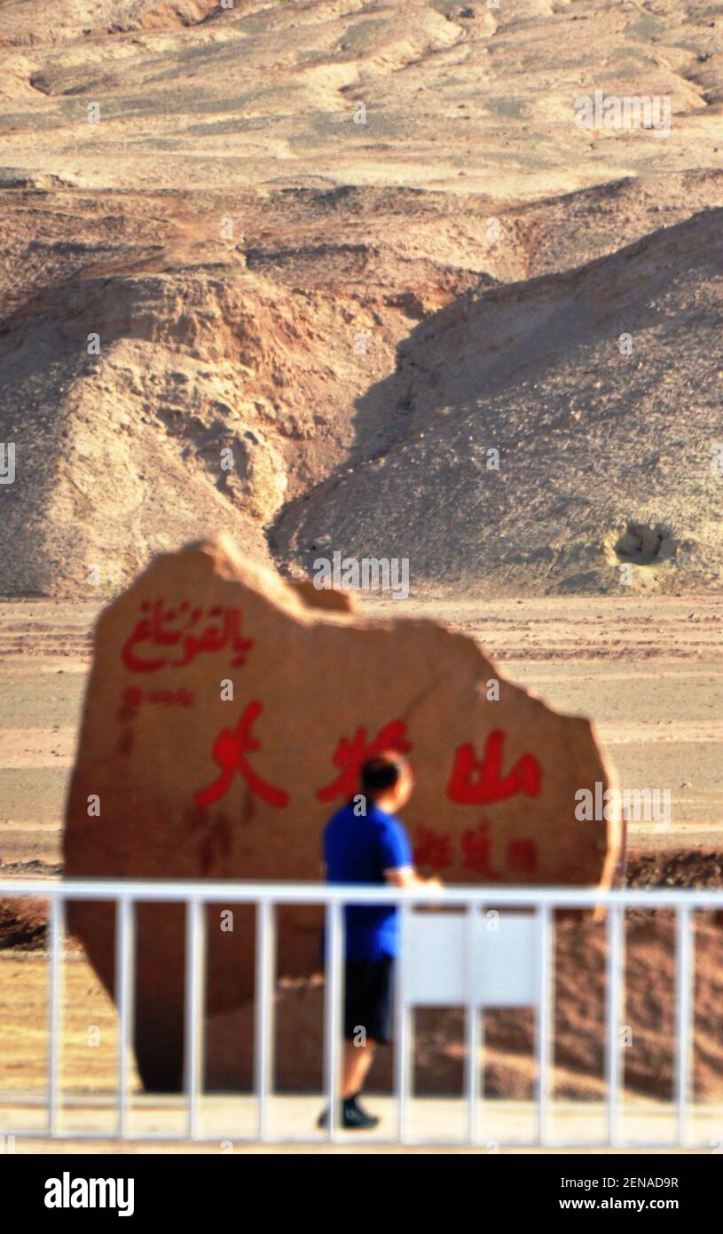 Tourists pose for photos with the landmark sculpture at the foot of the ...