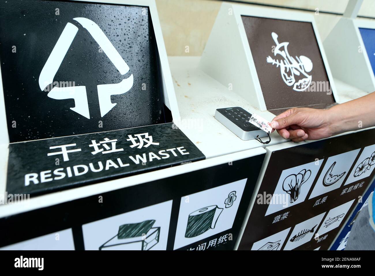 The man Niu Guangcheng from Gumei community's environment service center swipes his card to put ...