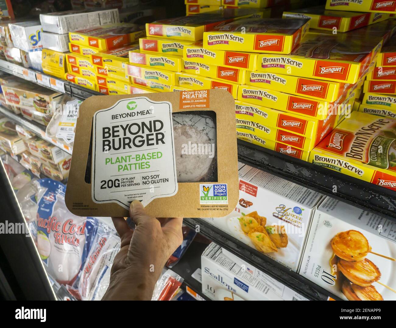 A discerning shopper chooses a package of Beyond Meat from a freezer in ...