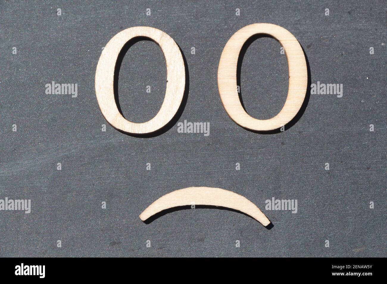 Sad face made with wooden pieces on gray background Stock Photo - Alamy