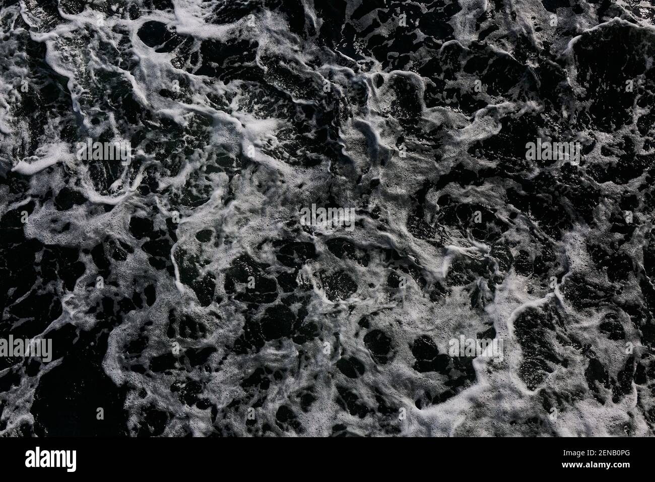 Waves in the ocean creating foam Stock Photo - Alamy