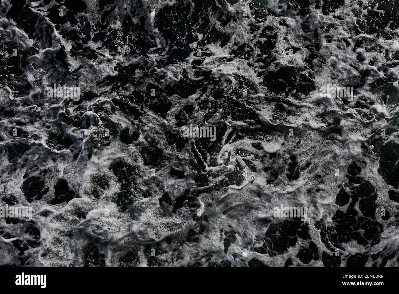 Waves in the ocean creating foam Stock Photo - Alamy