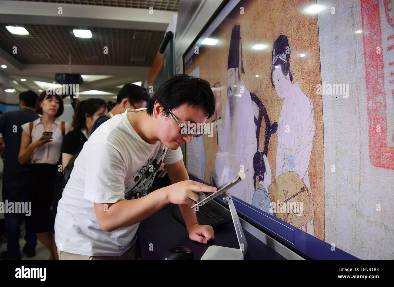 Visitors view a digital product on iPad tablet PC at the Palace Museum ...