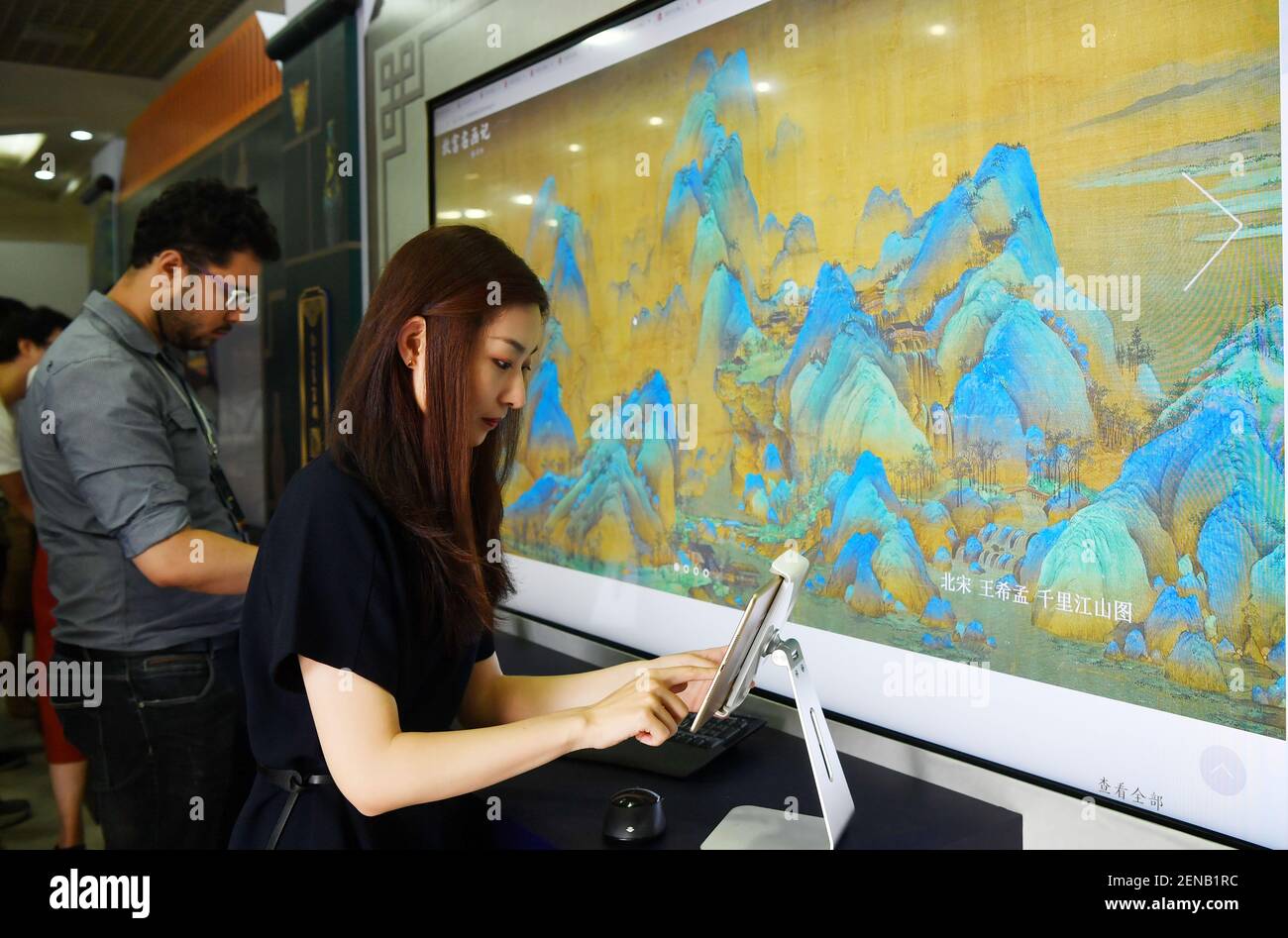 Visitors view a digital product on iPad tablet PC at the Palace Museum ...