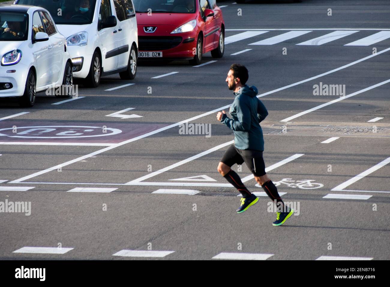 Man running in a city. Runner crossing a street Stock Photo - Alamy