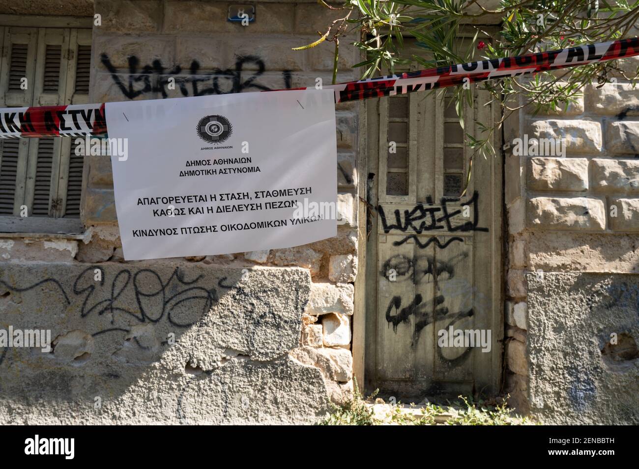 A police sign is seen in front of a derelict building warning people of ...