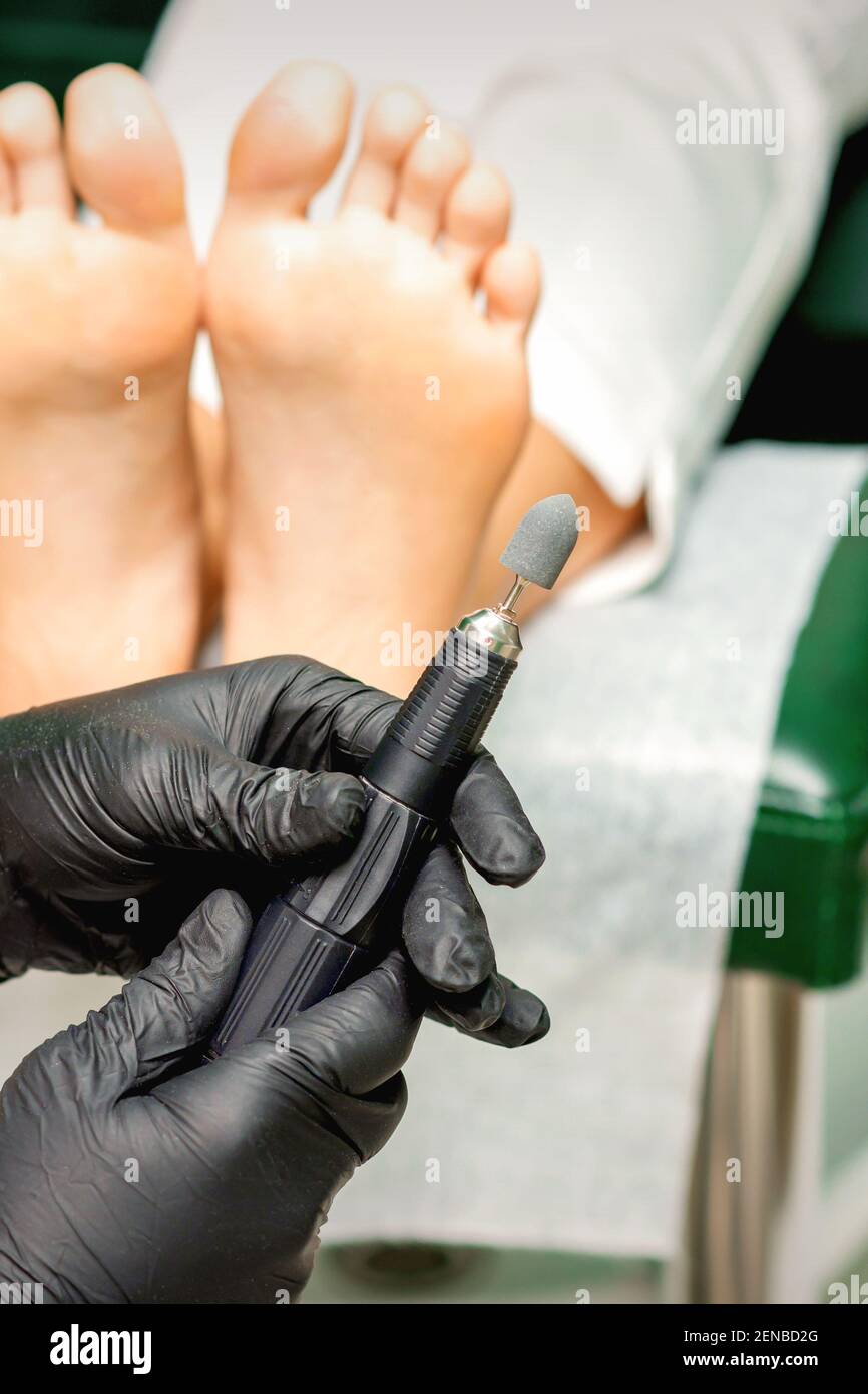 Chiropodist master prepares foot file machine before foot and toes ...