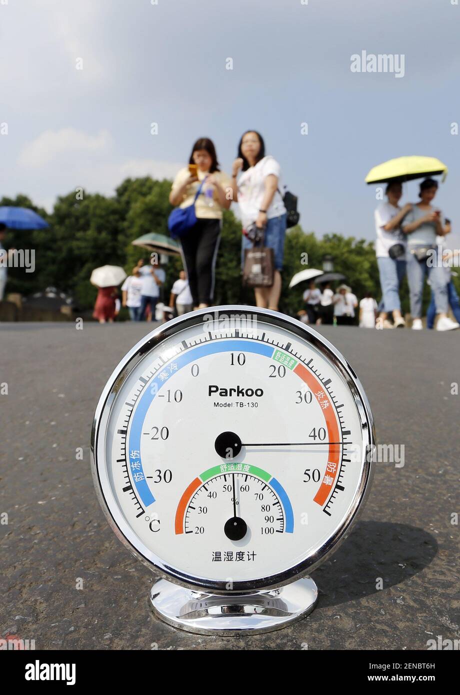 A local resident displays a thermometer showing the current temperature ...