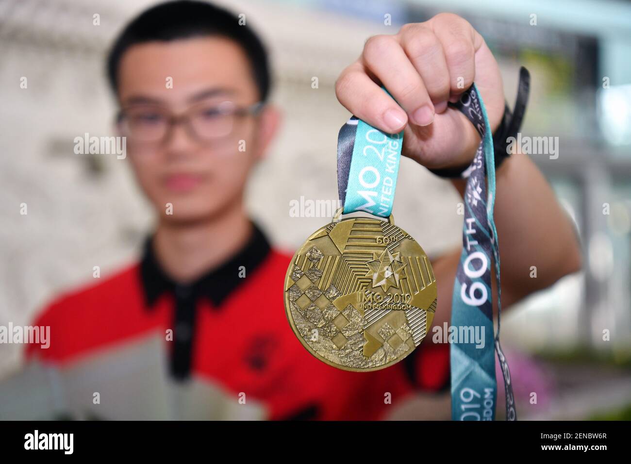 A high-school student from team China shows his gold medal at the ...