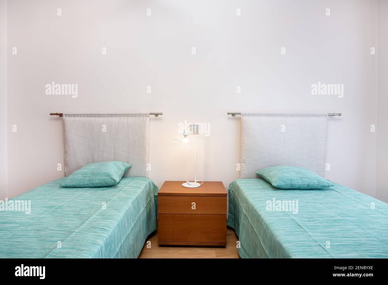 Simple front view of a bedroom with two single person beds and a ...