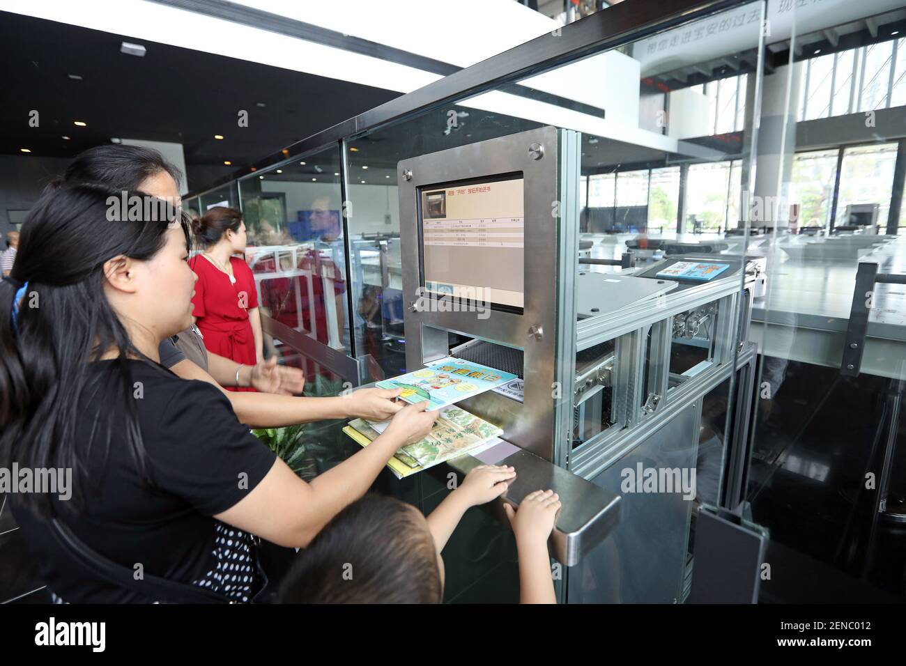 Readers experience robots in Shenzhen Baoan Library which helps them ...