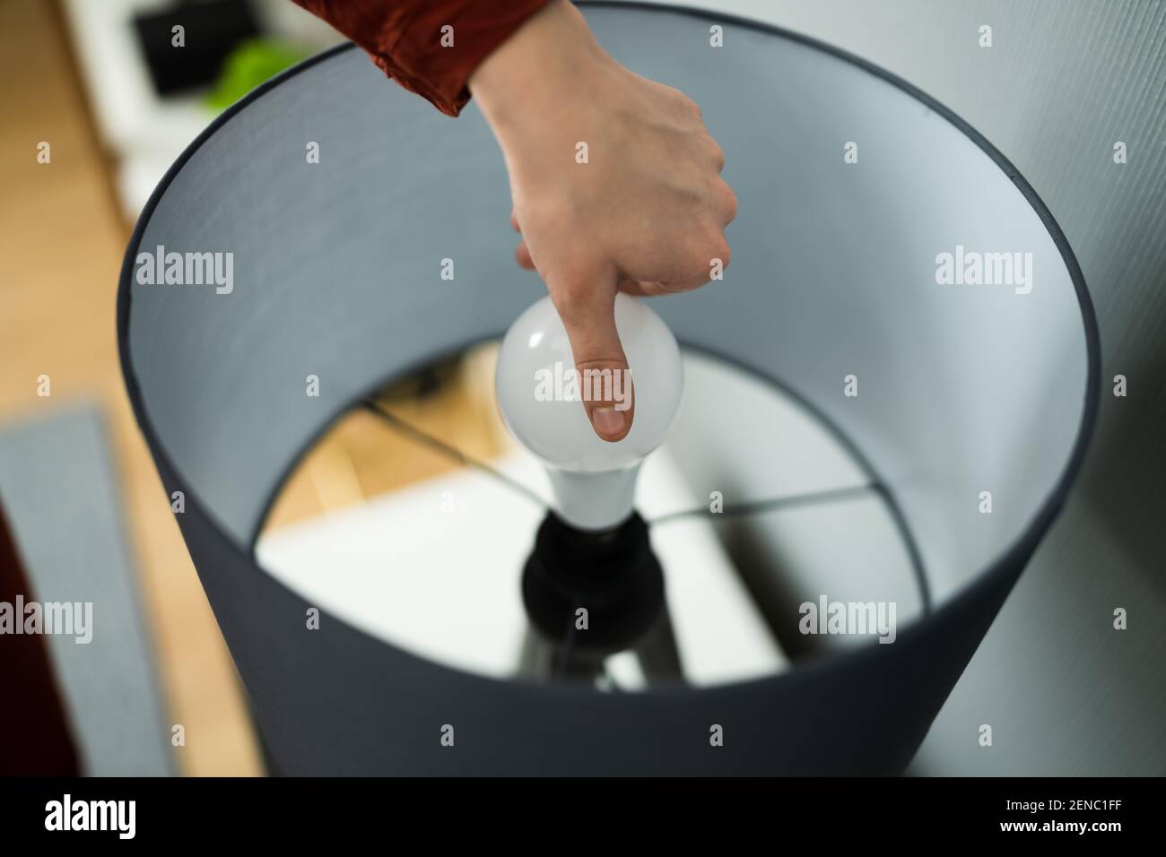 Woman Changing Broken Light Bulb To LED Stock Photo - Alamy