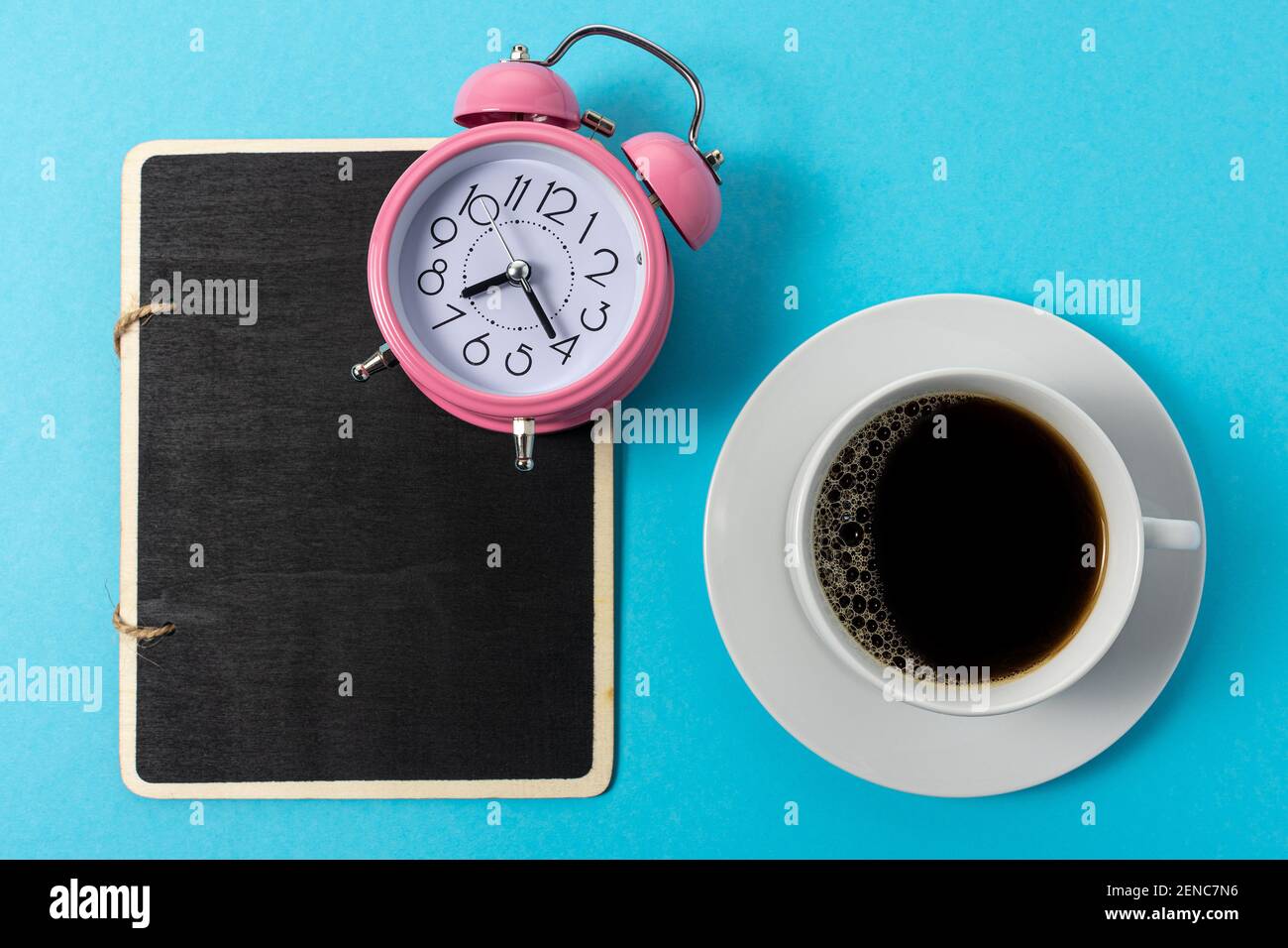 Creative layout made with cup of coffee and alarm clock on blue ...