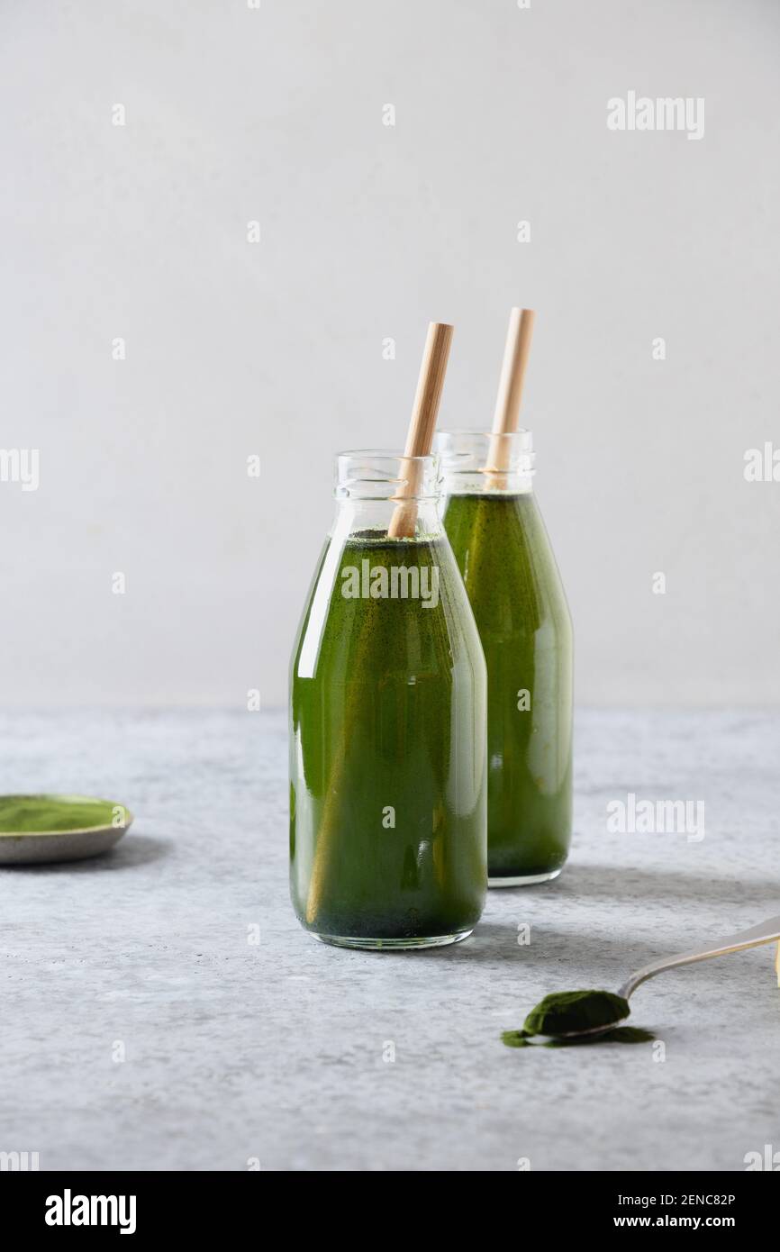 Two bottle with chlorella beverage on grey background. Vertical format ...