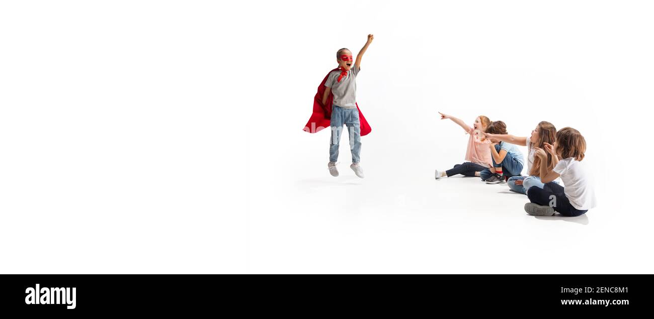 Flyer. Child pretending to be a superhero with her friends sitting ...