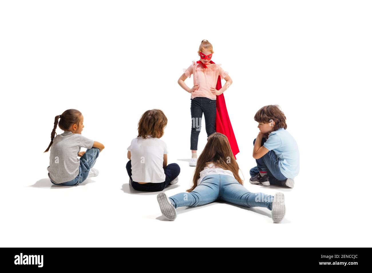 Leader. Child pretending to be a superhero with her friends sitting ...